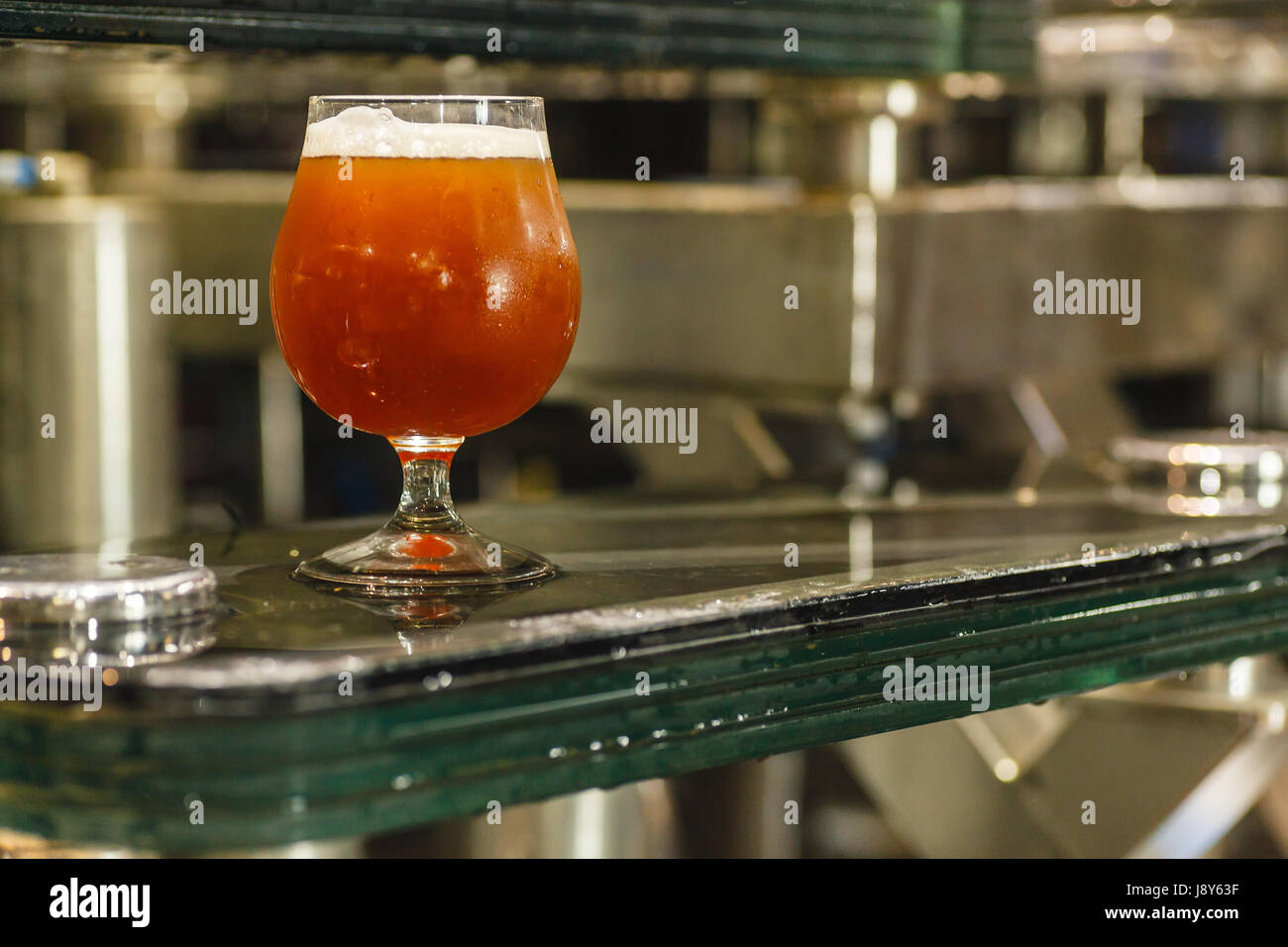 Glass full of amber ale beer standing on steps of an operating ...