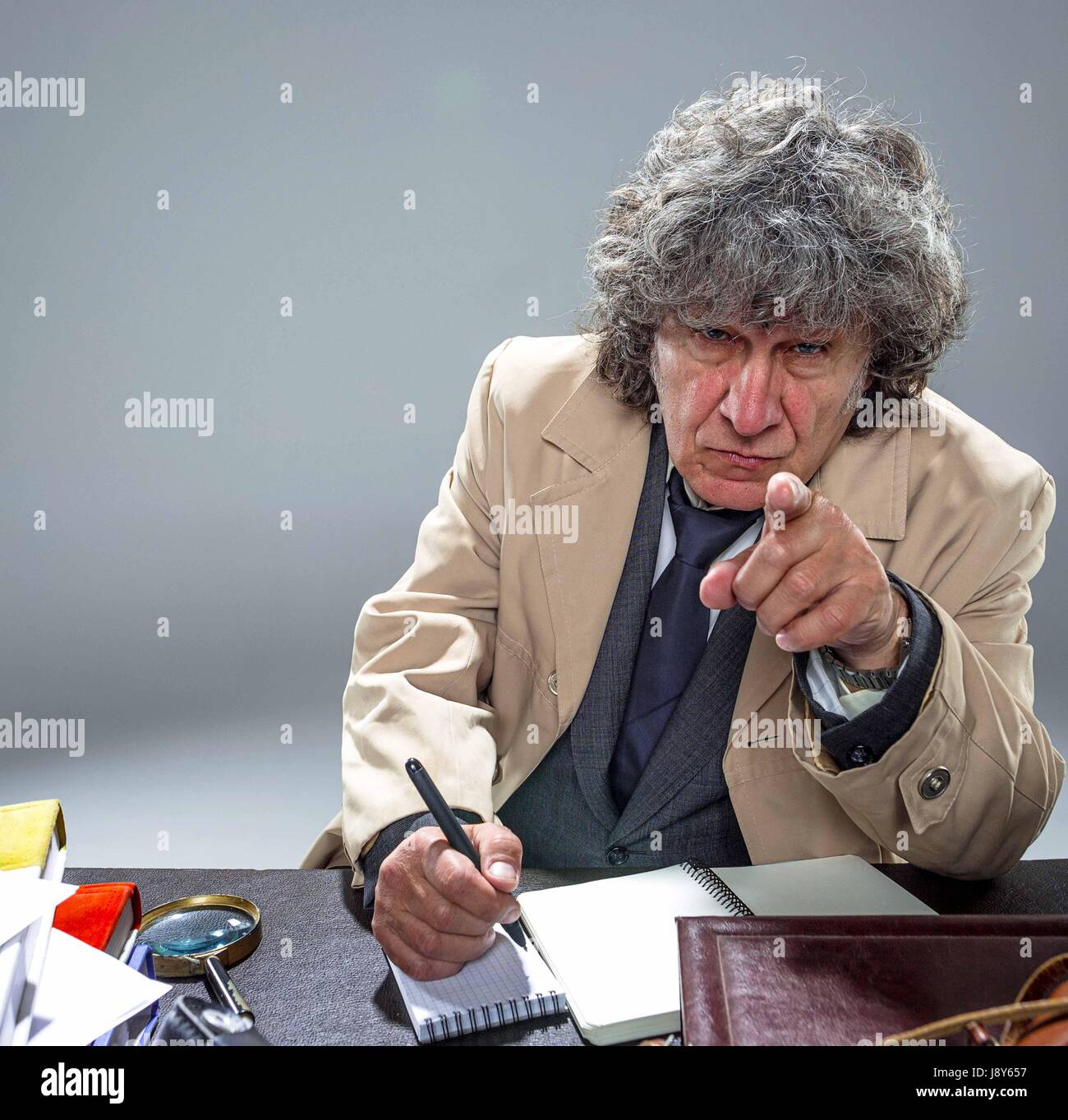 The senior man as detective or boss of mafia on gray studio background ...