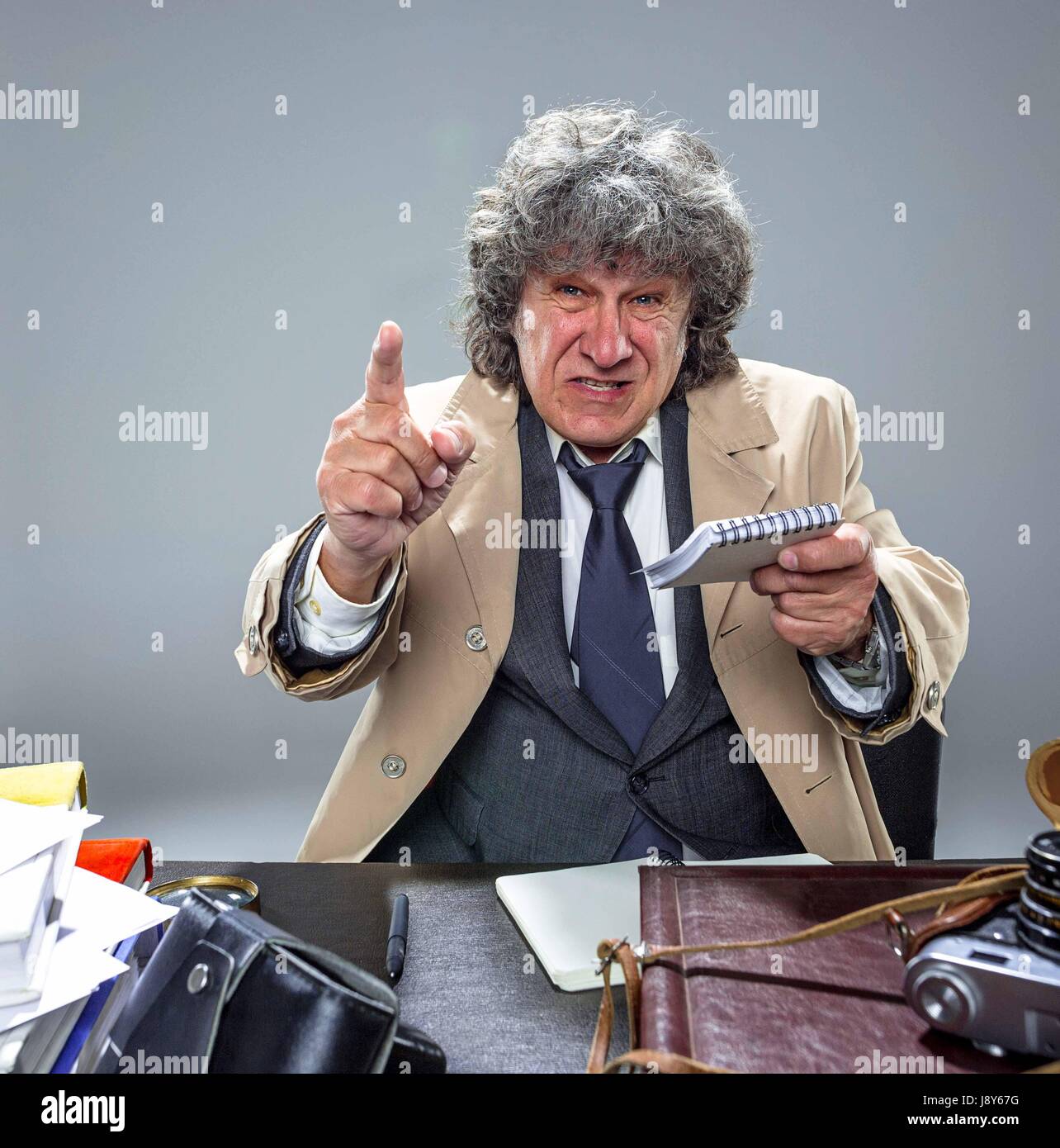 The senior man as detective or boss of mafia on gray studio background ...