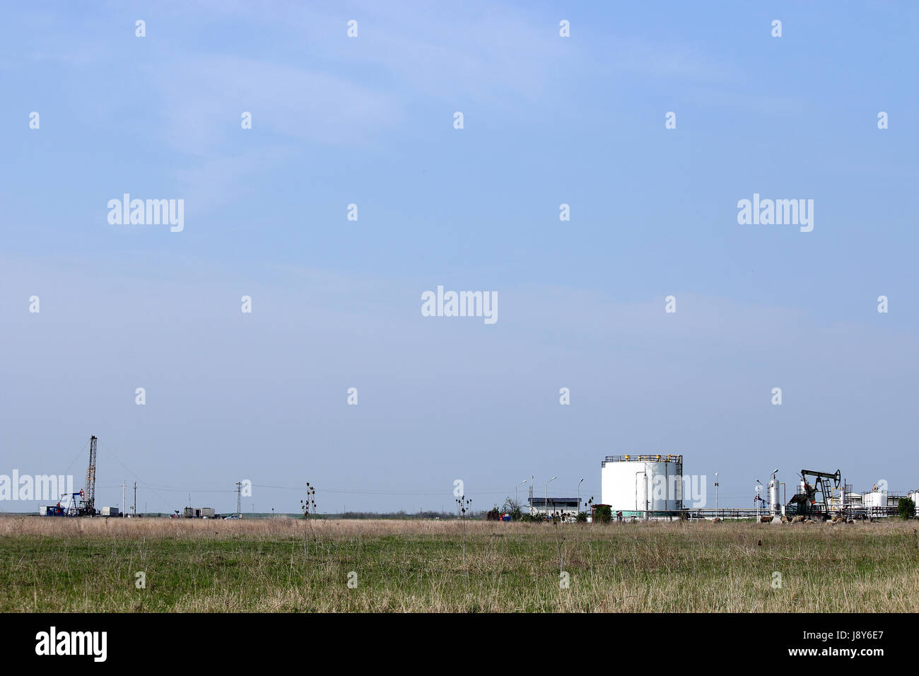 oilfield with land drilling rig oil pump jack and refinery tanks Stock ...