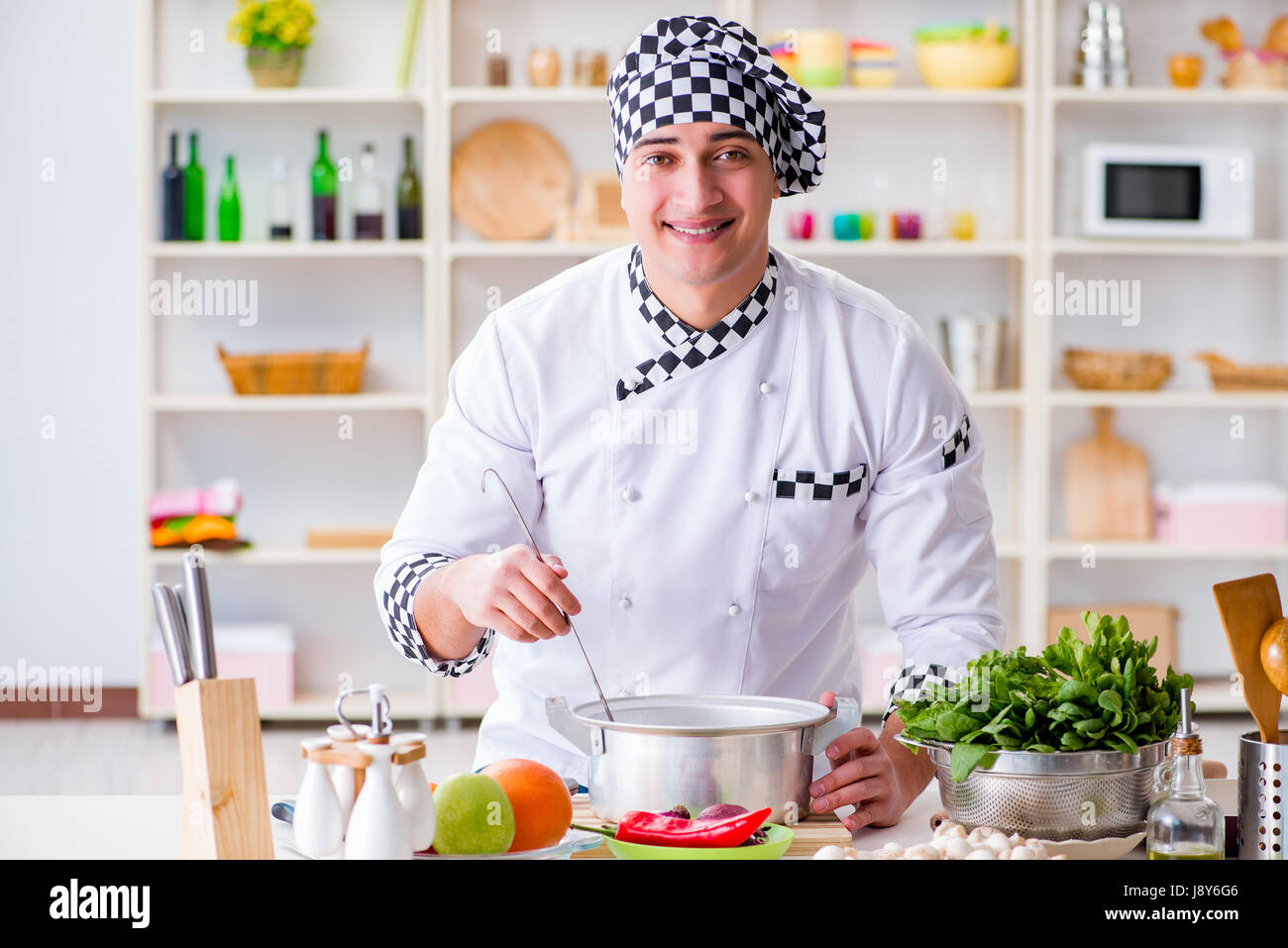 Young male cook working in the kitchen Stock Photo - Alamy