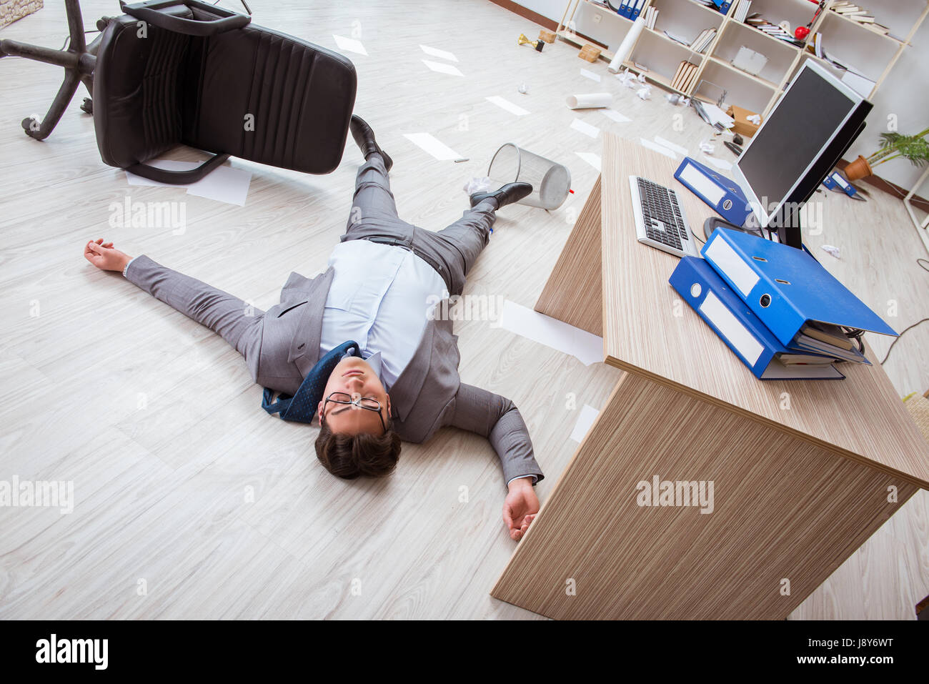 Businessman dead on the office floor Stock Photo - Alamy