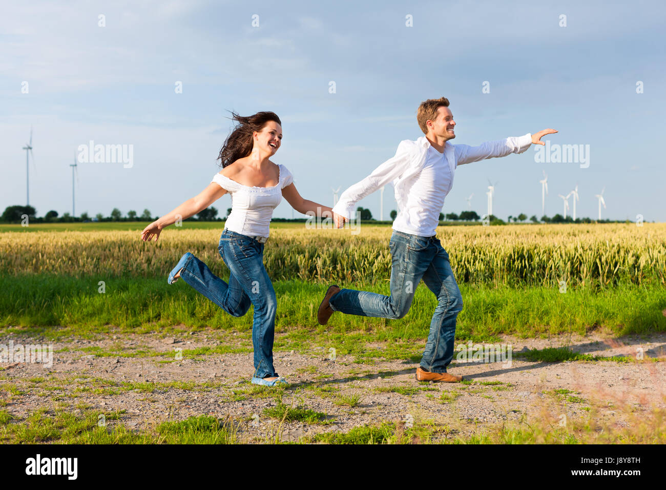 happy couple running on a meadow Stock Photo - Alamy