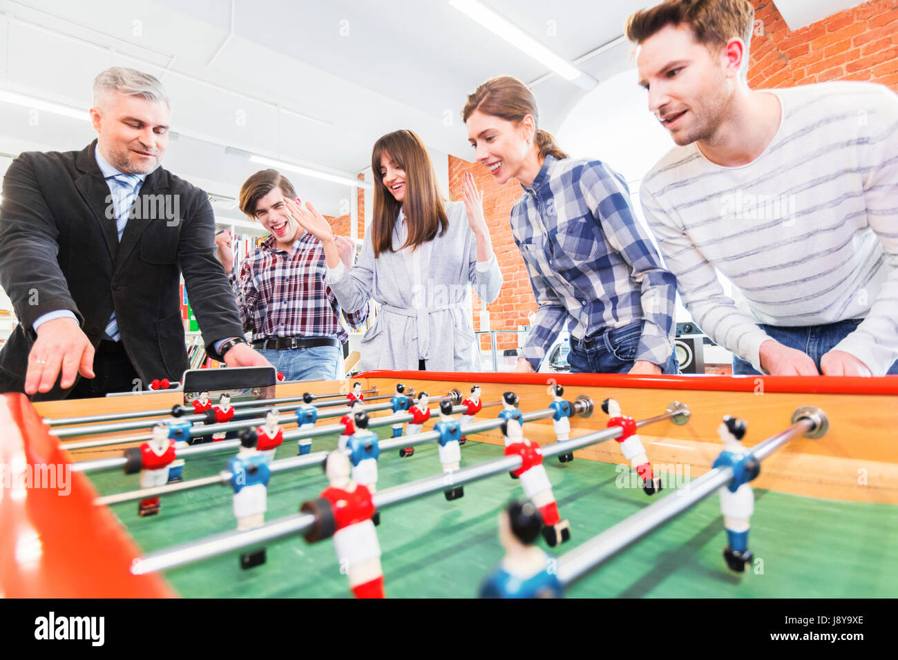 Happy friends playing table football hi-res stock photography and ...