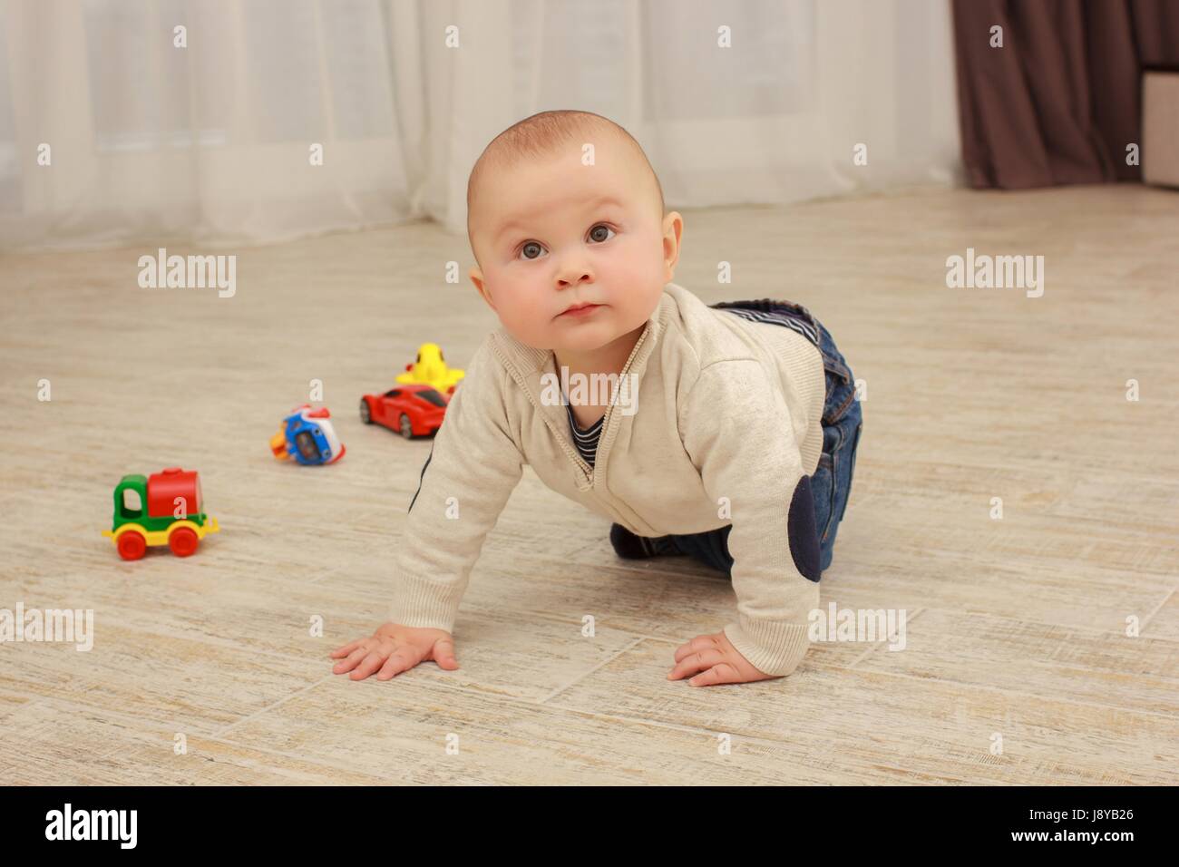 cute baby boy playing with toys in living room Stock Photo - Alamy
