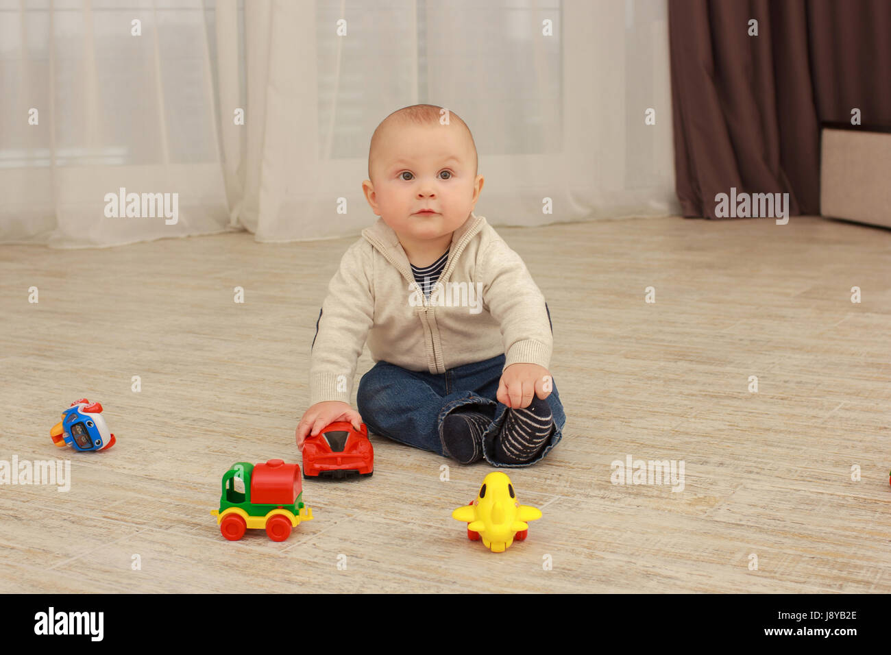 cute baby boy playing with toys in living room Stock Photo - Alamy