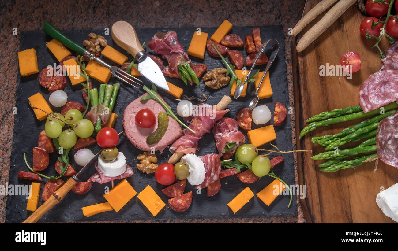 Top down view of a platter of cured meat (charcuterie), ham, salami ...
