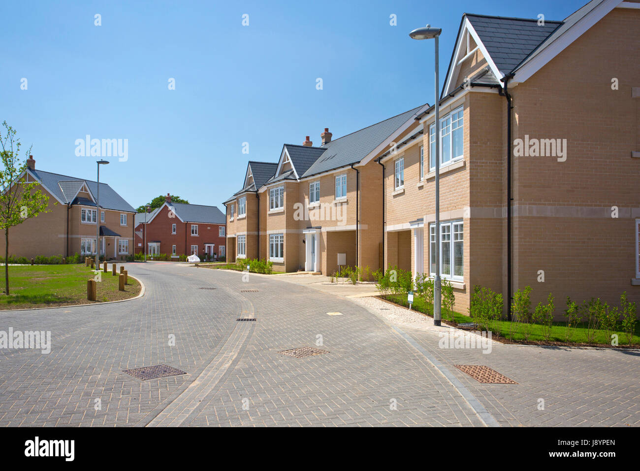 An empty street in a mostly complete new housing development Stock ...