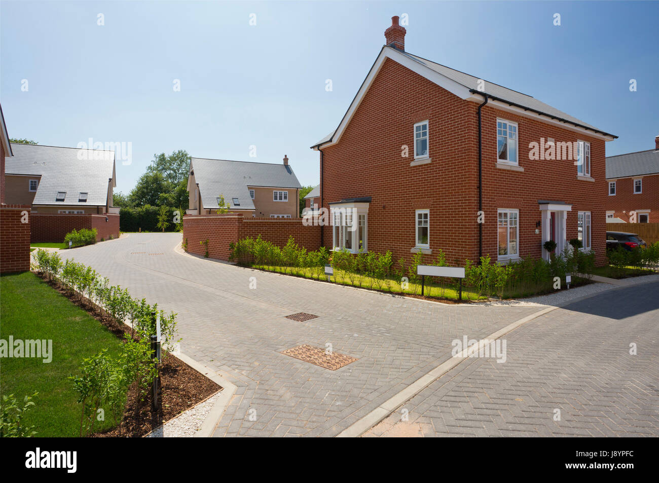 An empty street in a mostly complete new housing development, with ...