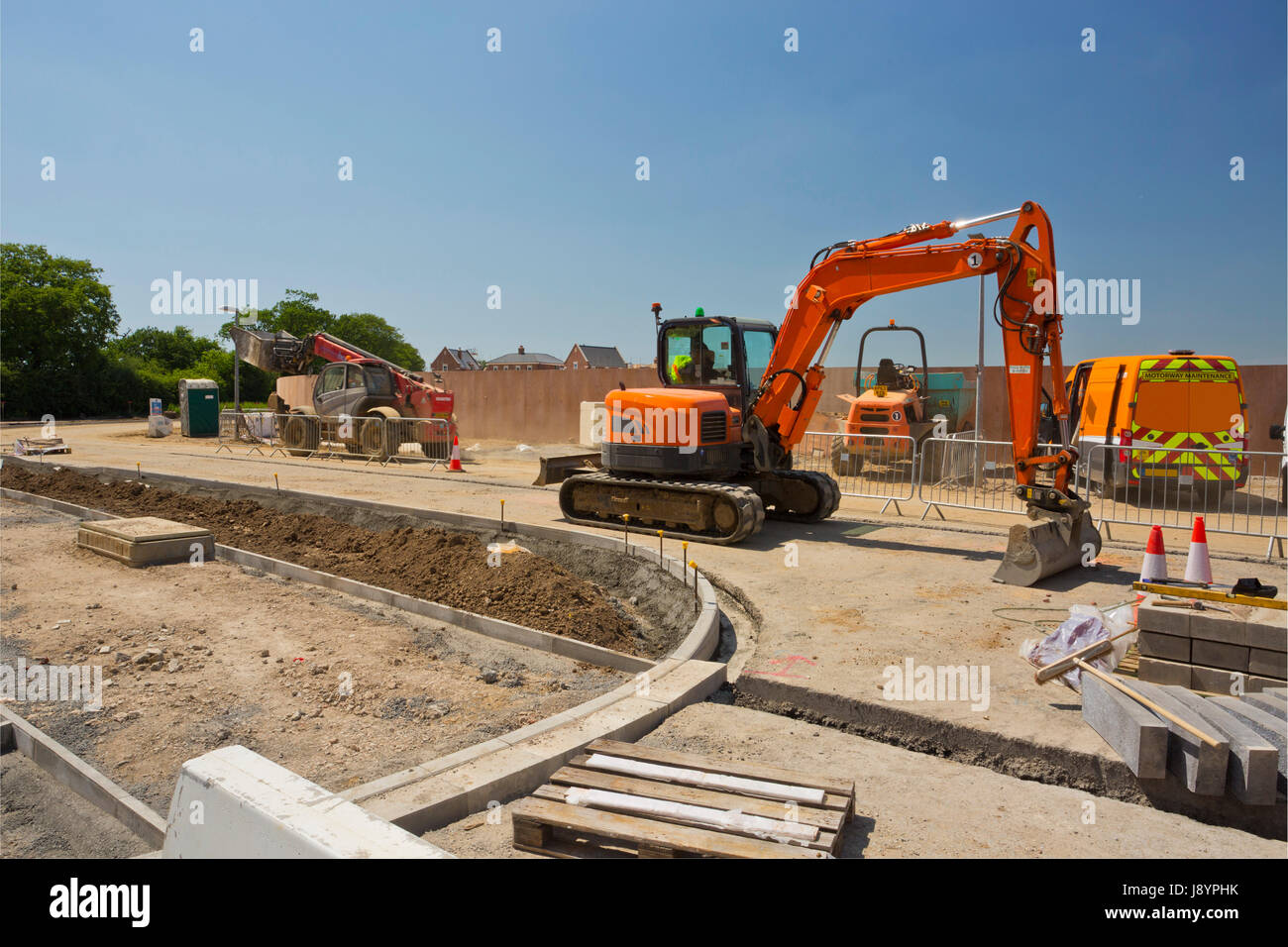Road building on a new housing development with diggers and fork lift ...