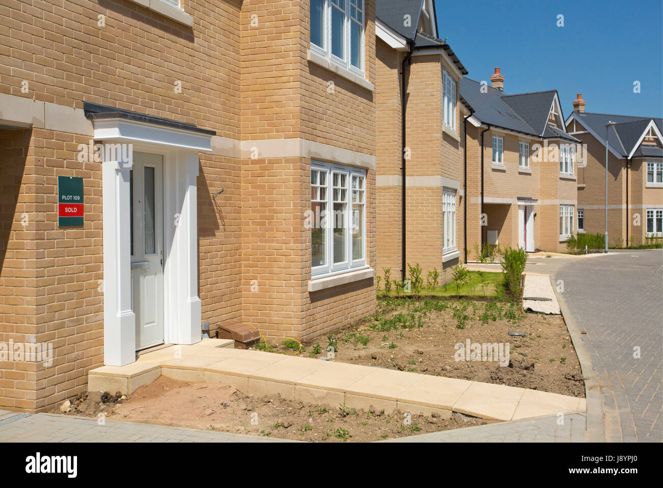 An empty street in a mostly complete new housing development, with ...