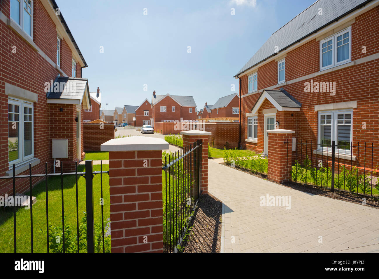 An empty street in a mostly complete new housing development, with ...