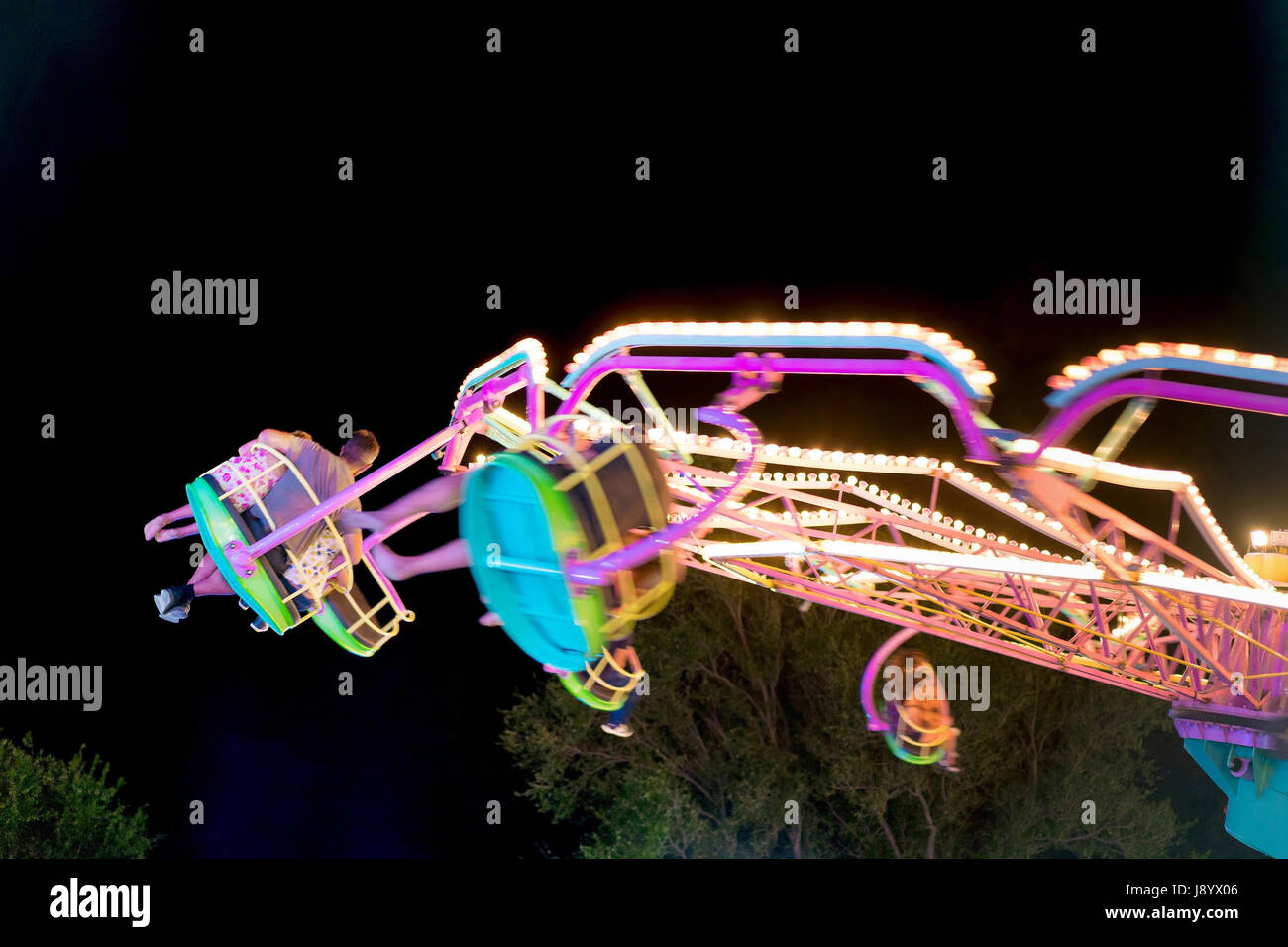 Carousel on chains rolling with a high speed at night in Omis, Croatia ...