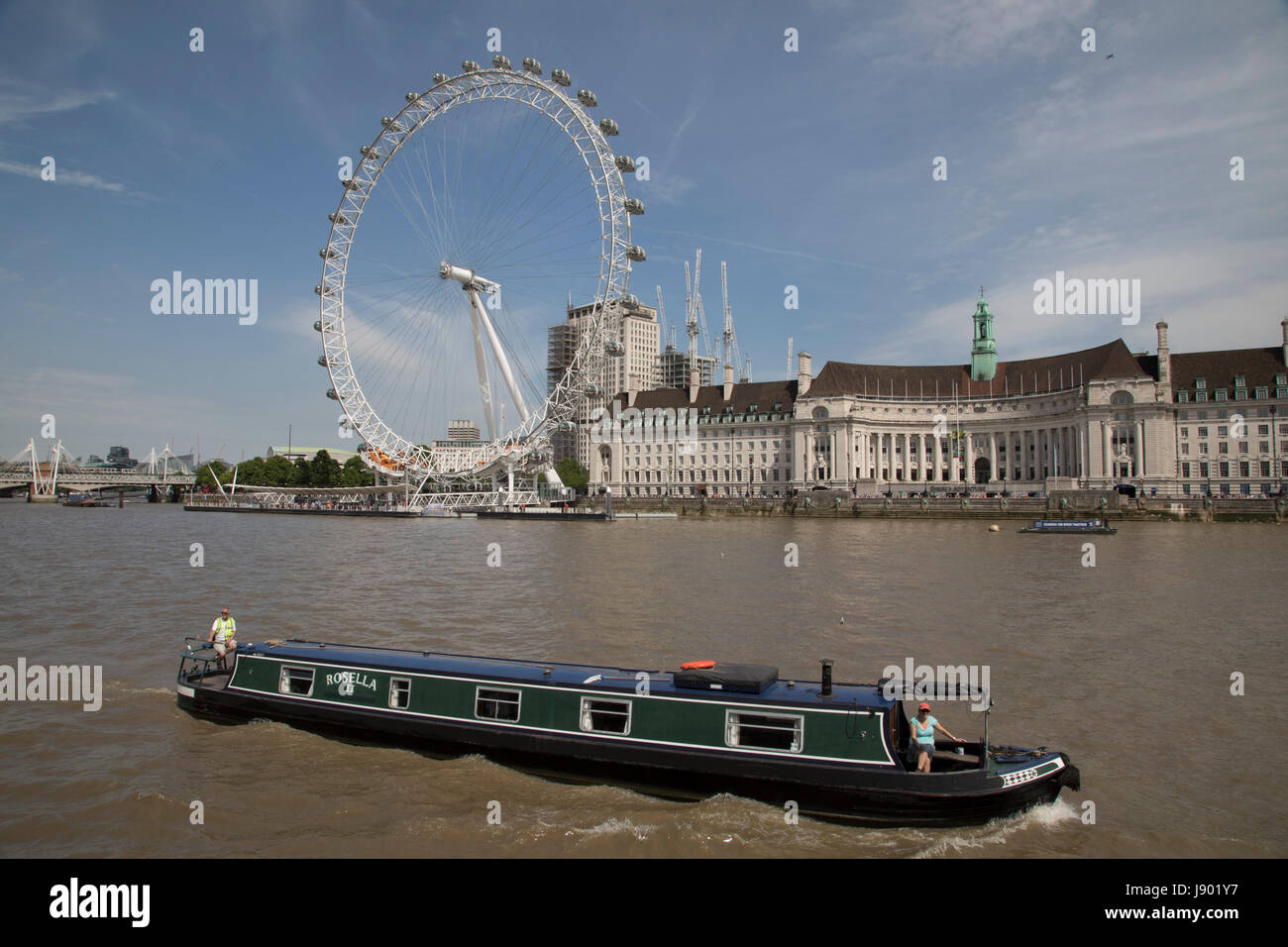 Tourists take a sightseeing tour cruise boat down the River Thames ...
