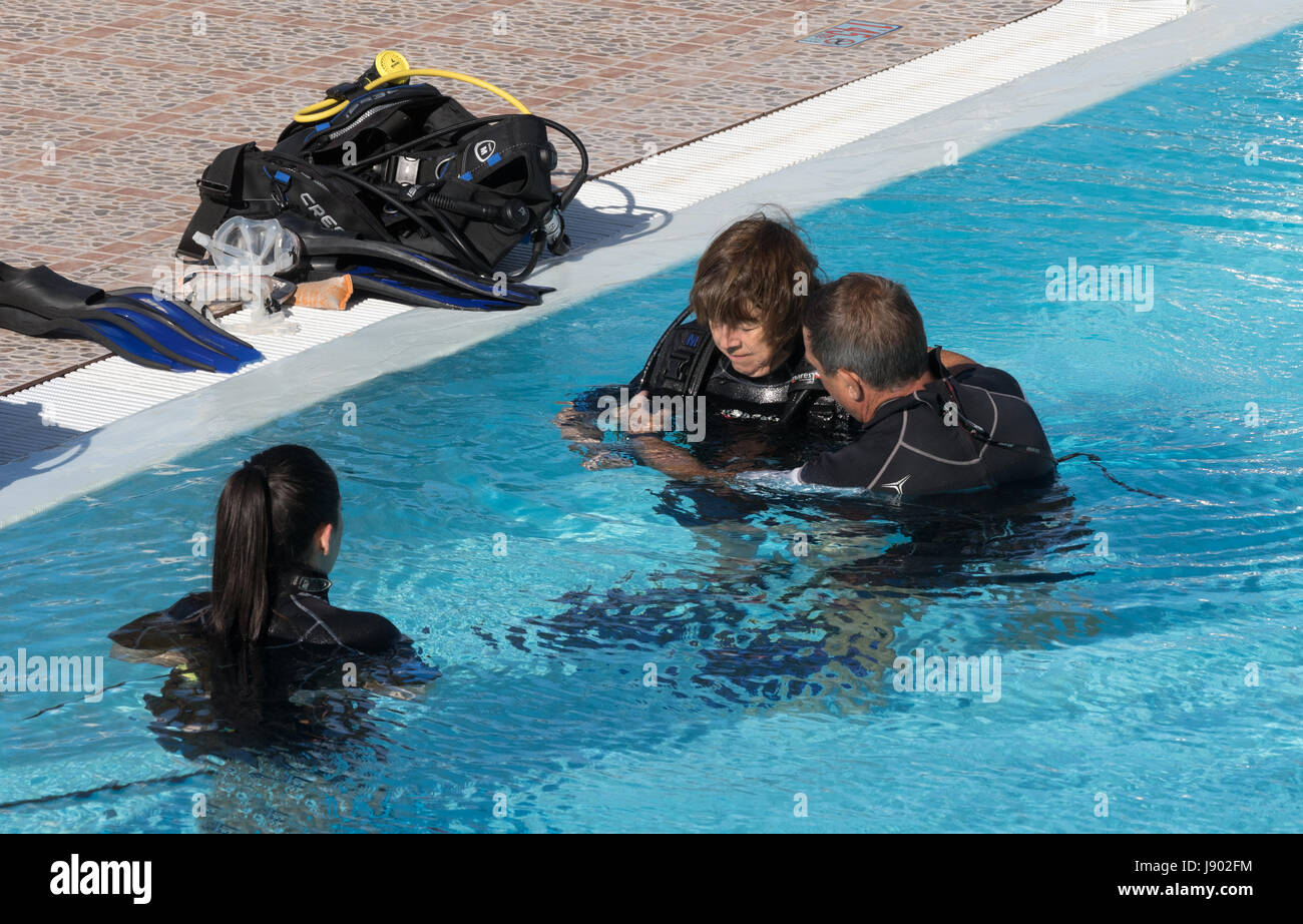 Two women learning scuba diving in a swimming pool, Lanzarote, Canary ...