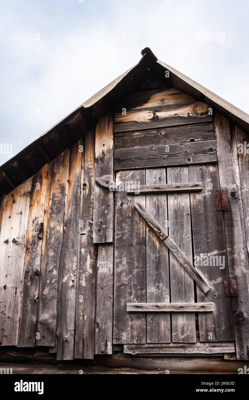 Top part old rustic wooden house - an attic with small door. View from ...
