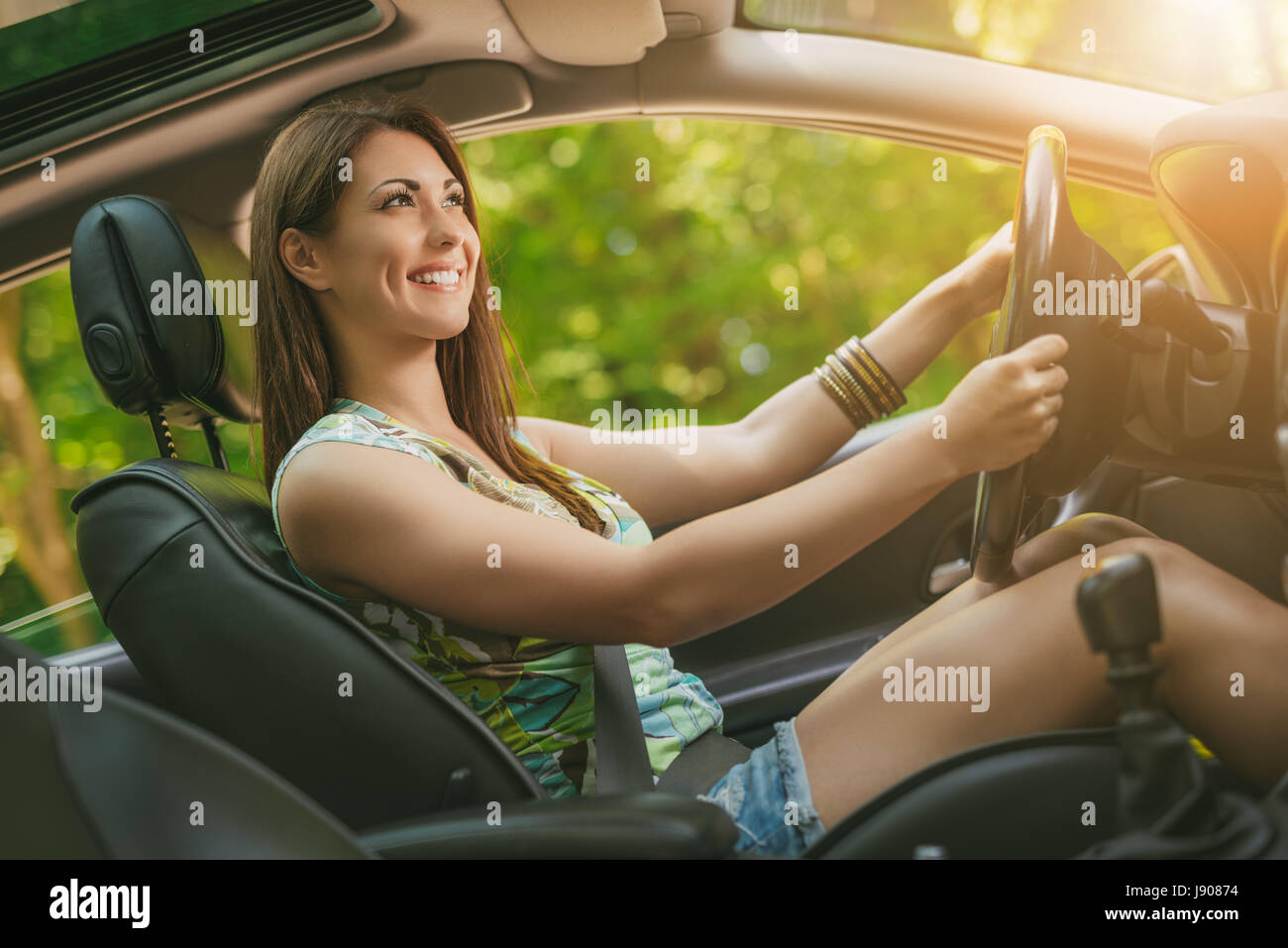Young beautiful smiling girl driving a car Stock Photo - Alamy