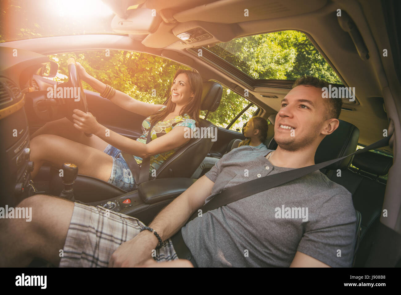 Mother driving a car with family on a road trip hi-res stock ...