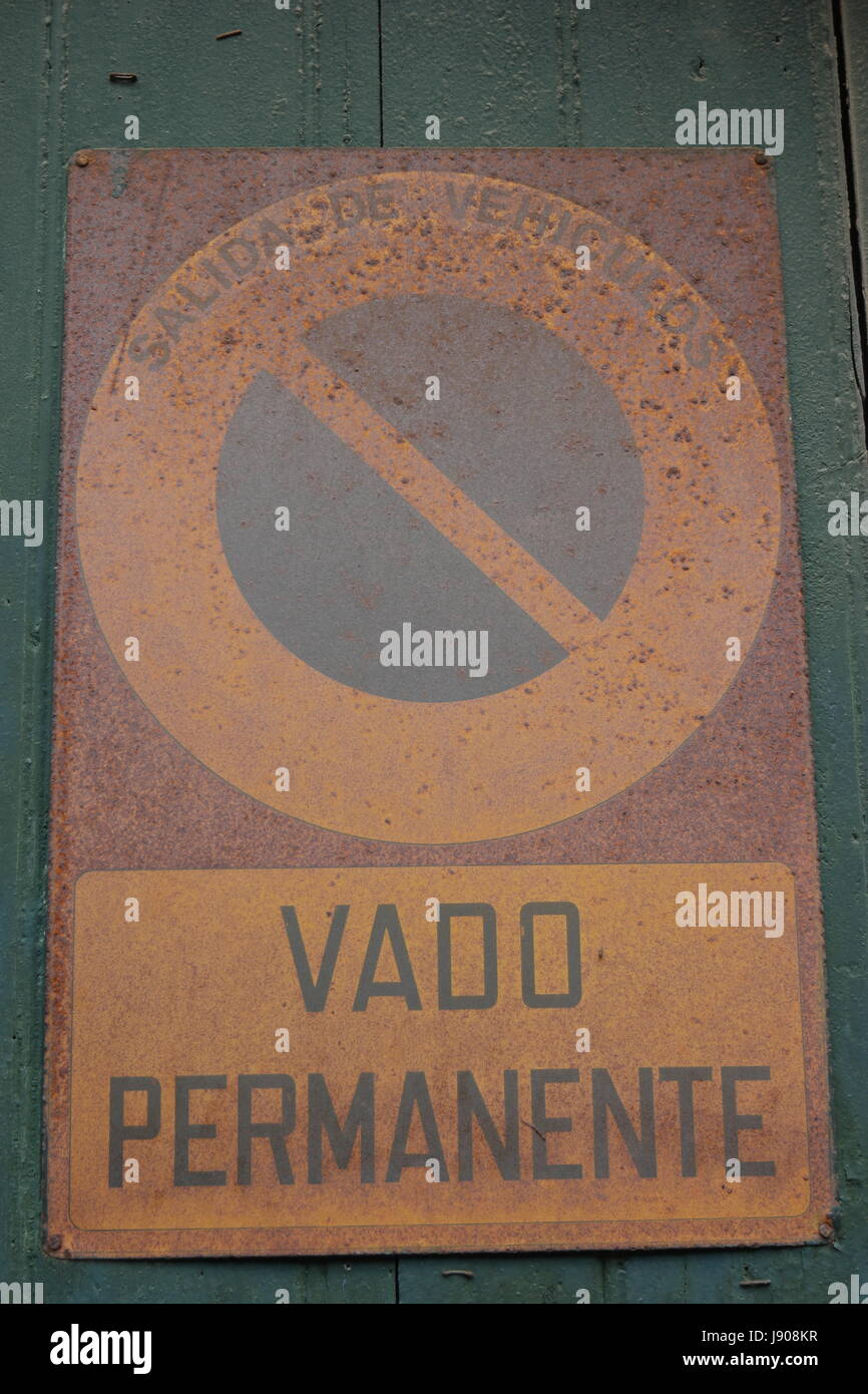 A rusty sign saying "vado permanente" and showing a parking forbidden ...