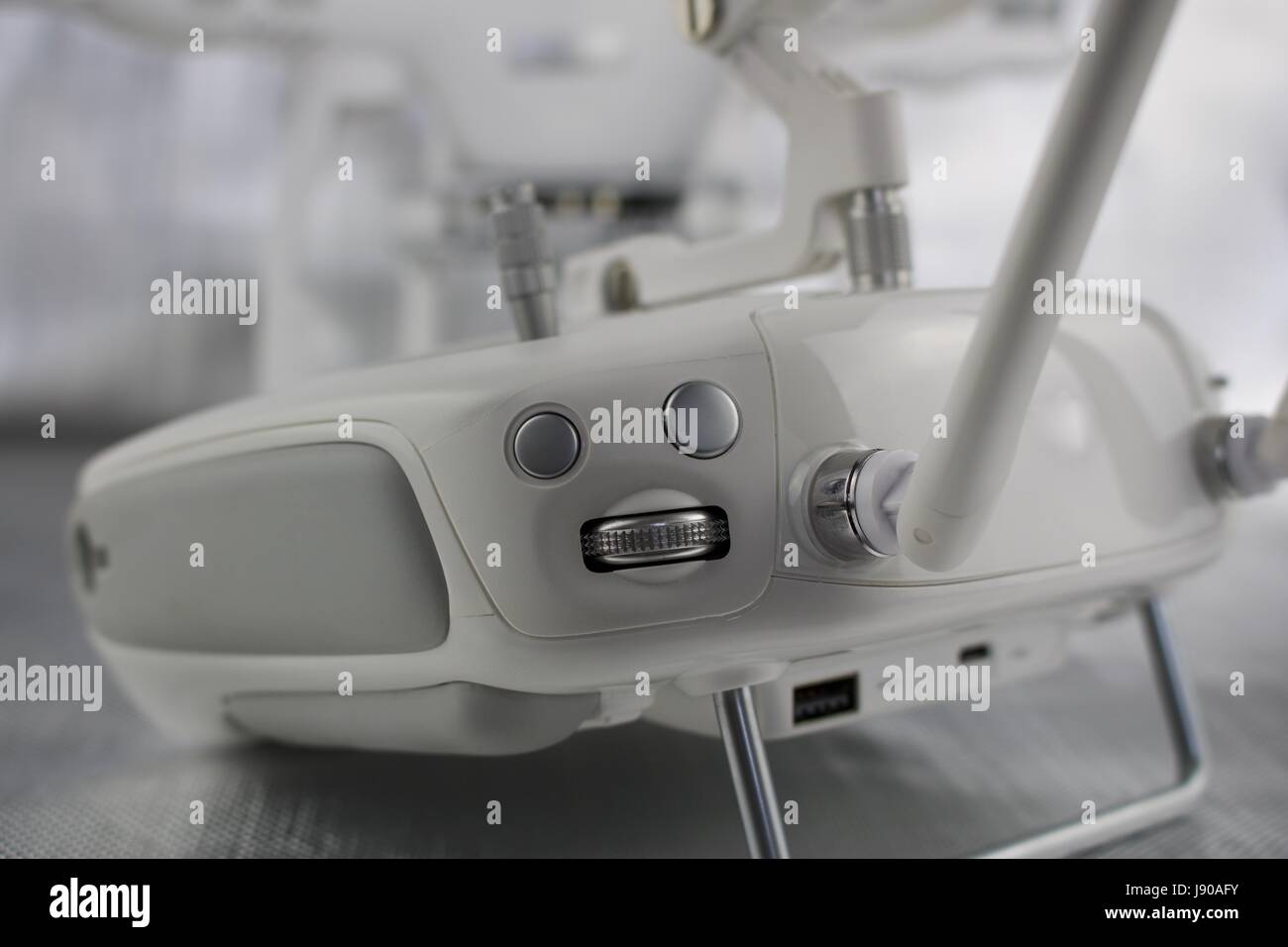 Drone white hand controller on the silver background near big aircraft ...