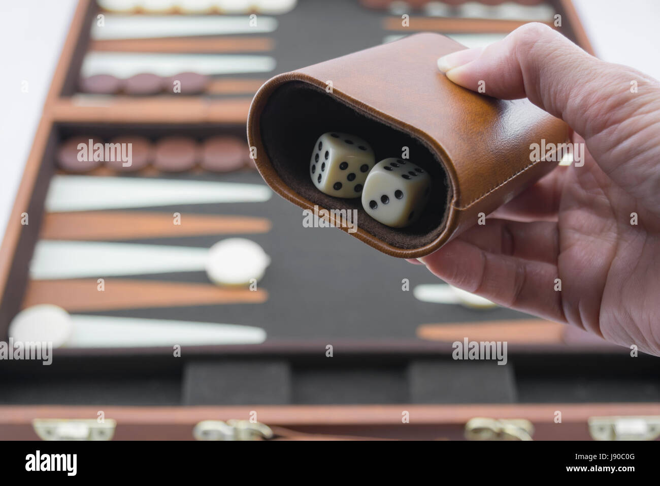 Readying to roll backgammon dice on the brown and cream backgammon ...