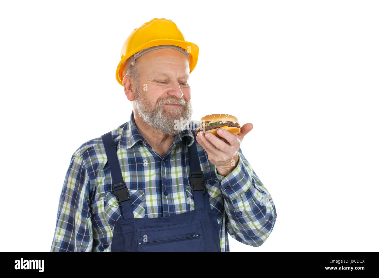 Picture of a hungry mechanic having a lunch break, eating hamburger ...
