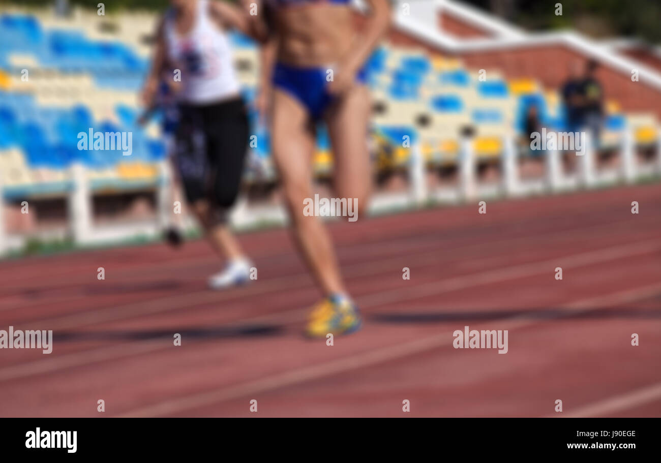 Blurred view of athletic running competition at stadium not in focus ...