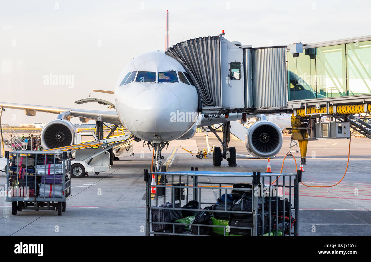 Loading baggage on airplane Stock Photo - Alamy