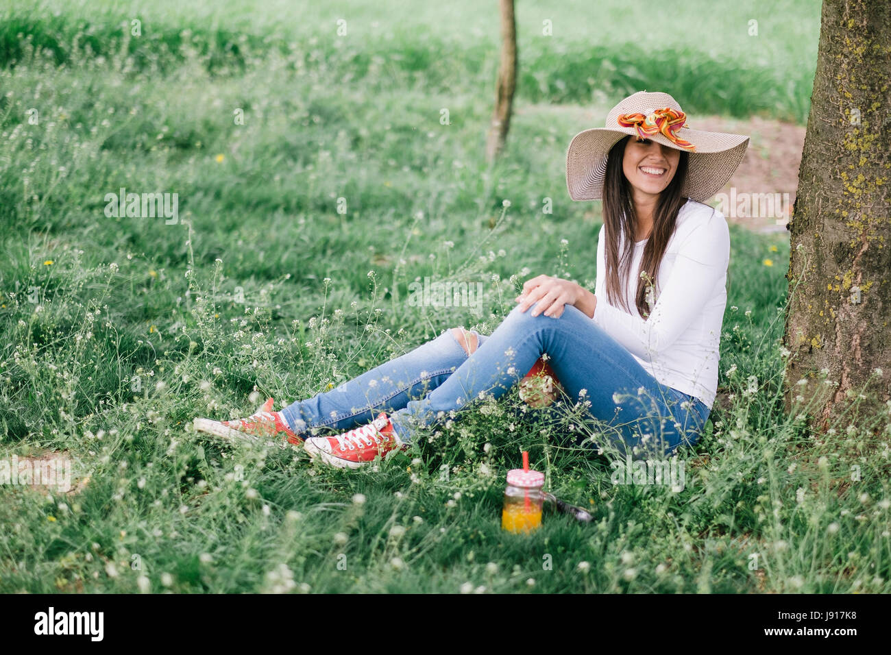 Woman relaxing under tree hi-res stock photography and images - Alamy