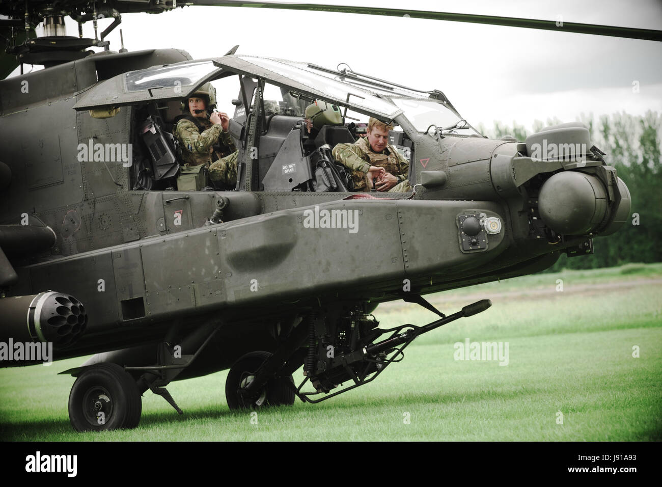 Army Air Corps AH-64 Apache attack helicopter with crew preparing to ...