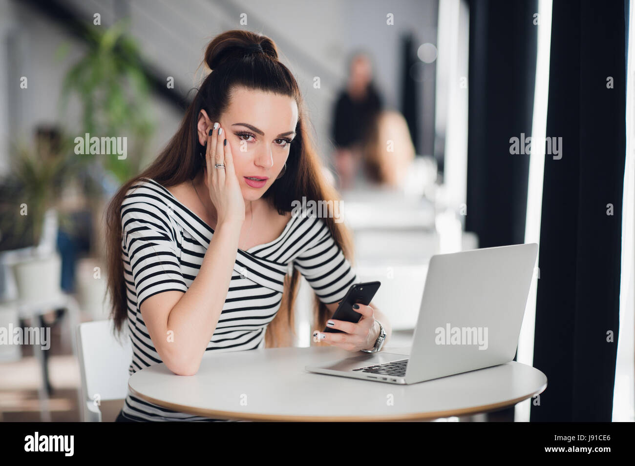 Woman with serious expression full of shock and perplexity is holding a ...