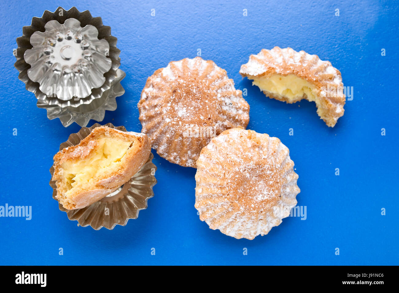 Sweet tarts with vanilla cream on a blue background Stock Photo - Alamy