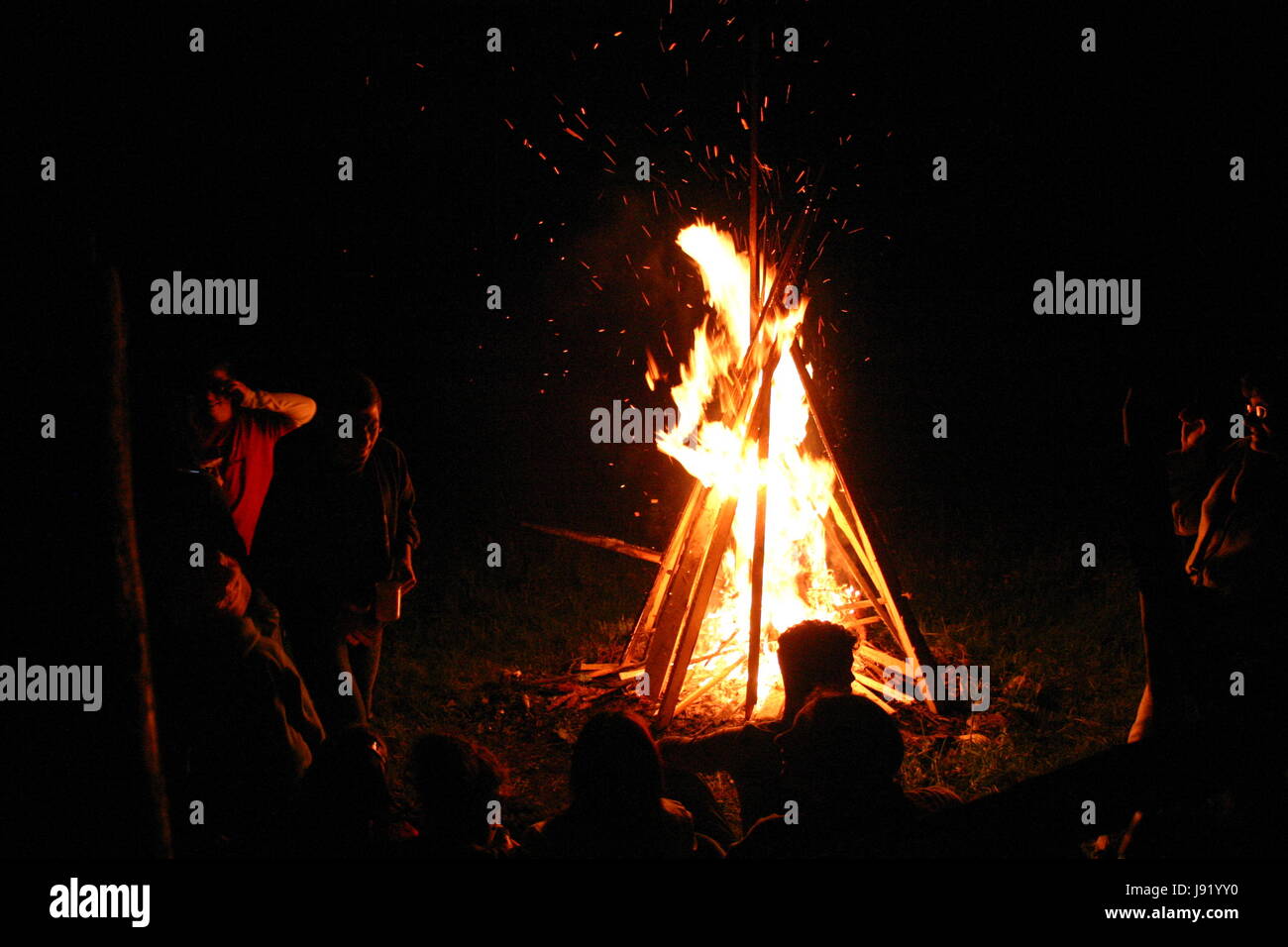 People around tall hot and bright bonfire Stock Photo - Alamy