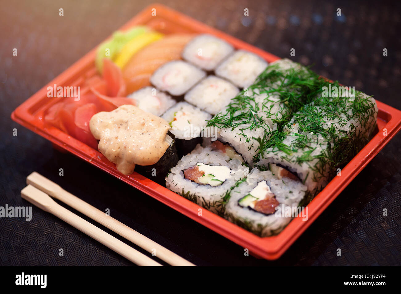 Japanese sushi in red plastic container for carrying food on black ...