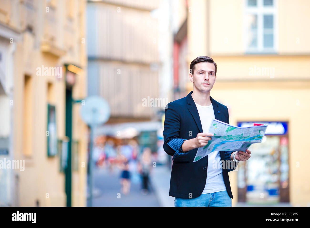 Man tourist with a city map in Europe. Young guy looking at the map of ...