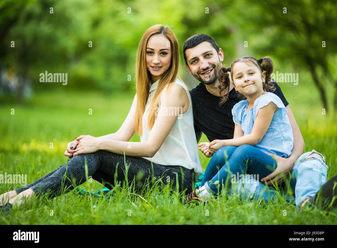 Happy mother, father and daughter playing in the park Stock Photo - Alamy