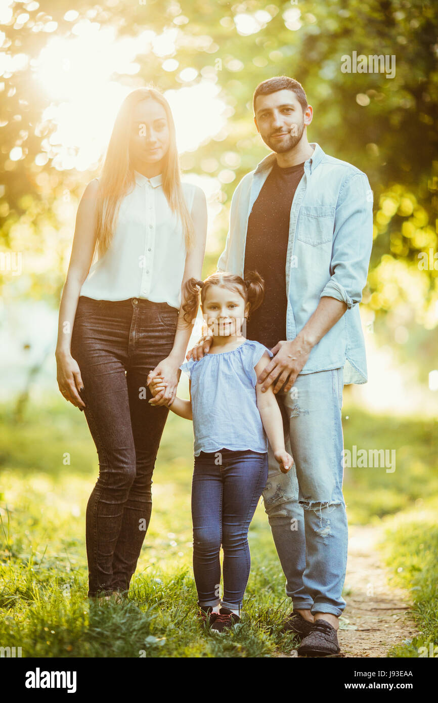 Happy mother, father and daughter in sunset Stock Photo - Alamy