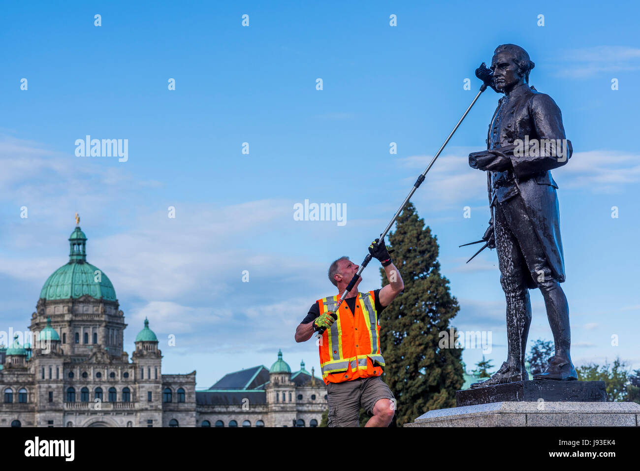 City worker washing statue of Capt. Cook, British Columbia Legislature ...