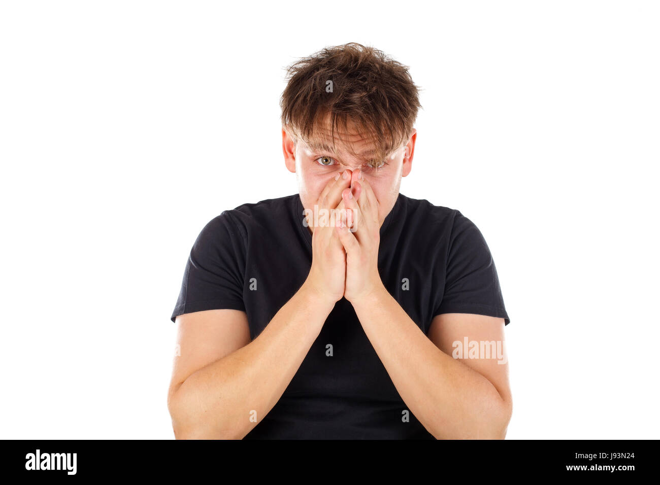 Picture of a nervous young man standing on an isolated background Stock ...
