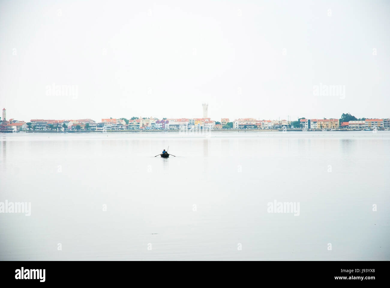 Lonely fishing boat with cityscape behind Stock Photo - Alamy