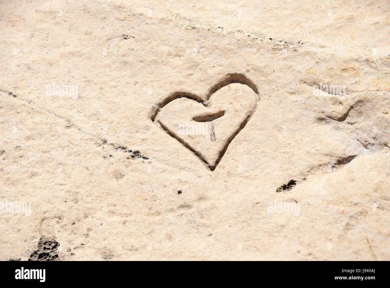Carved heart with initials in the rock Stock Photo - Alamy