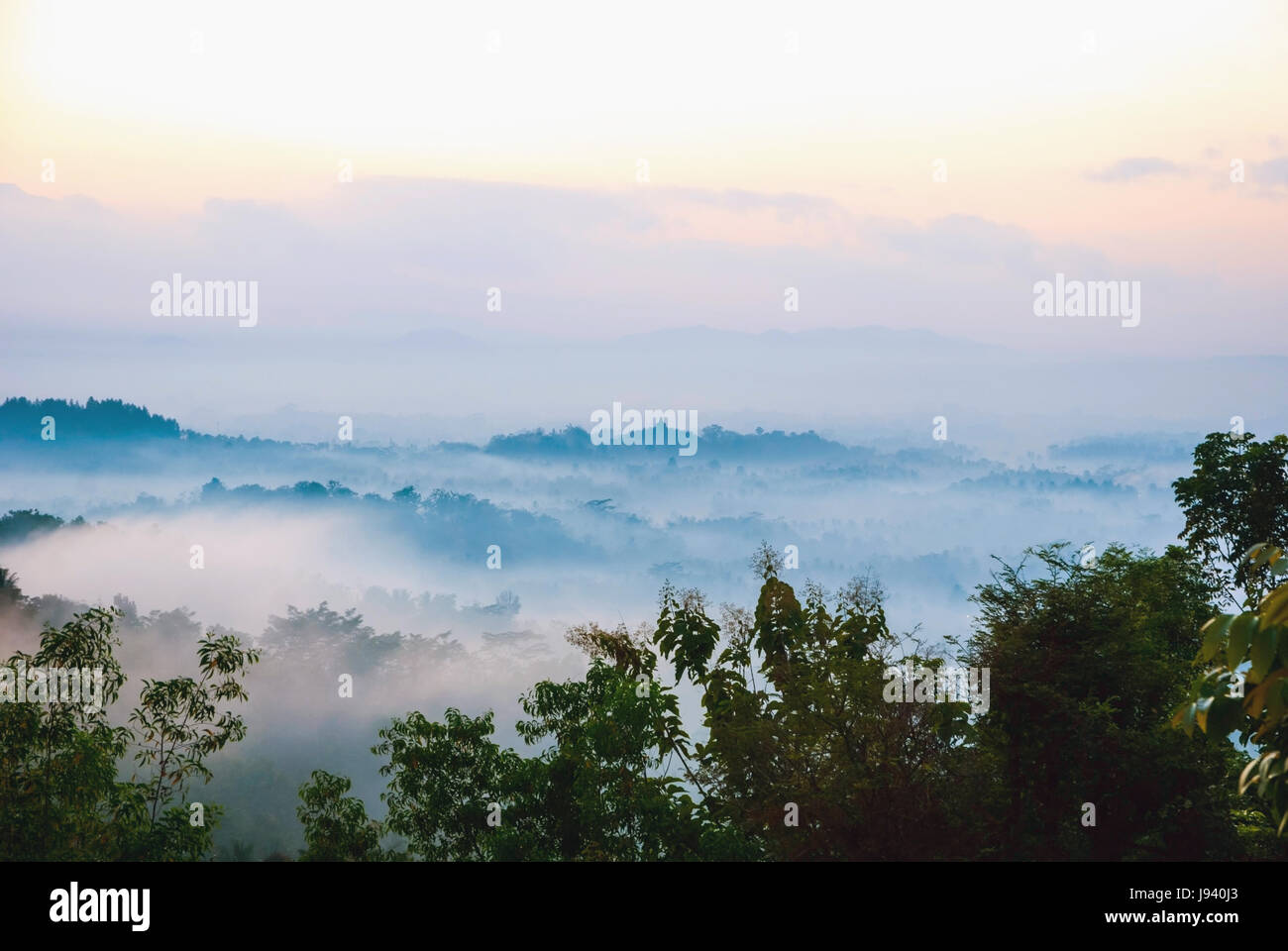 Colorful sunrise over jungle with Merapi volcano behind and Borobudur ...