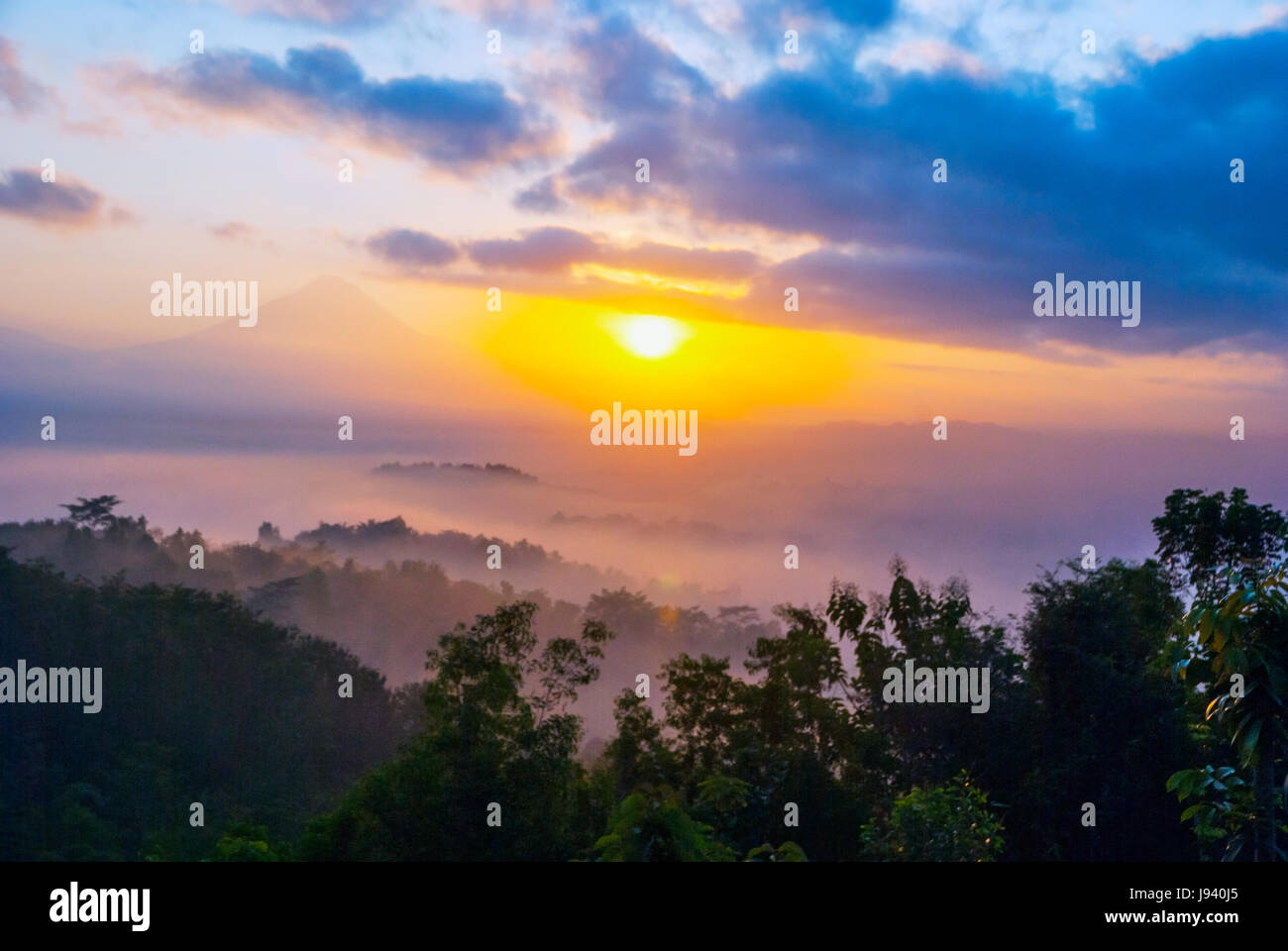 Colorful sunrise over jungle with Merapi volcano behind and Borobudur ...