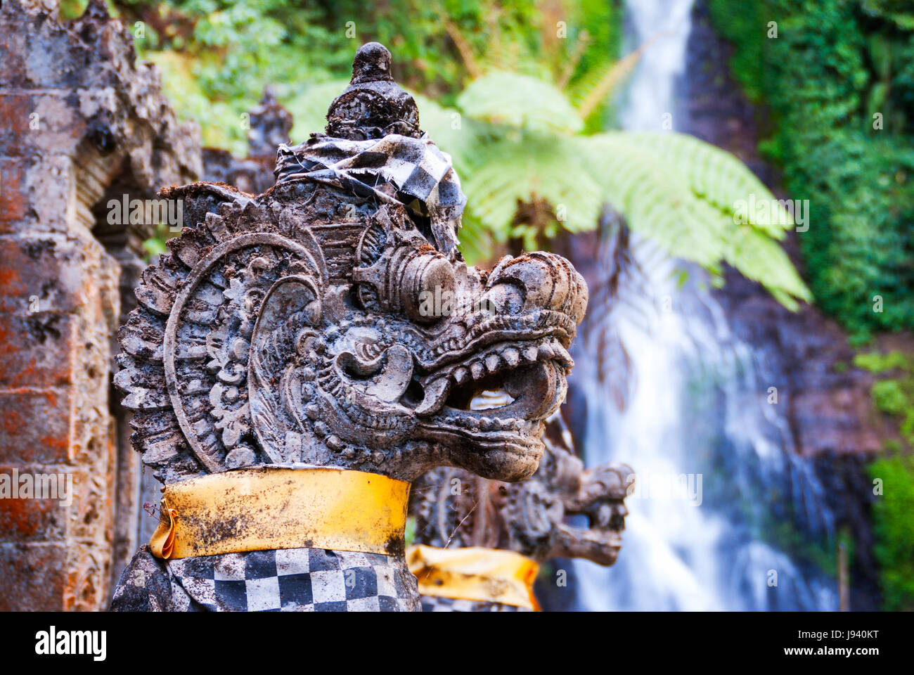 Details of dragon statues at hindu temple with waterfall behind. Gitgit ...