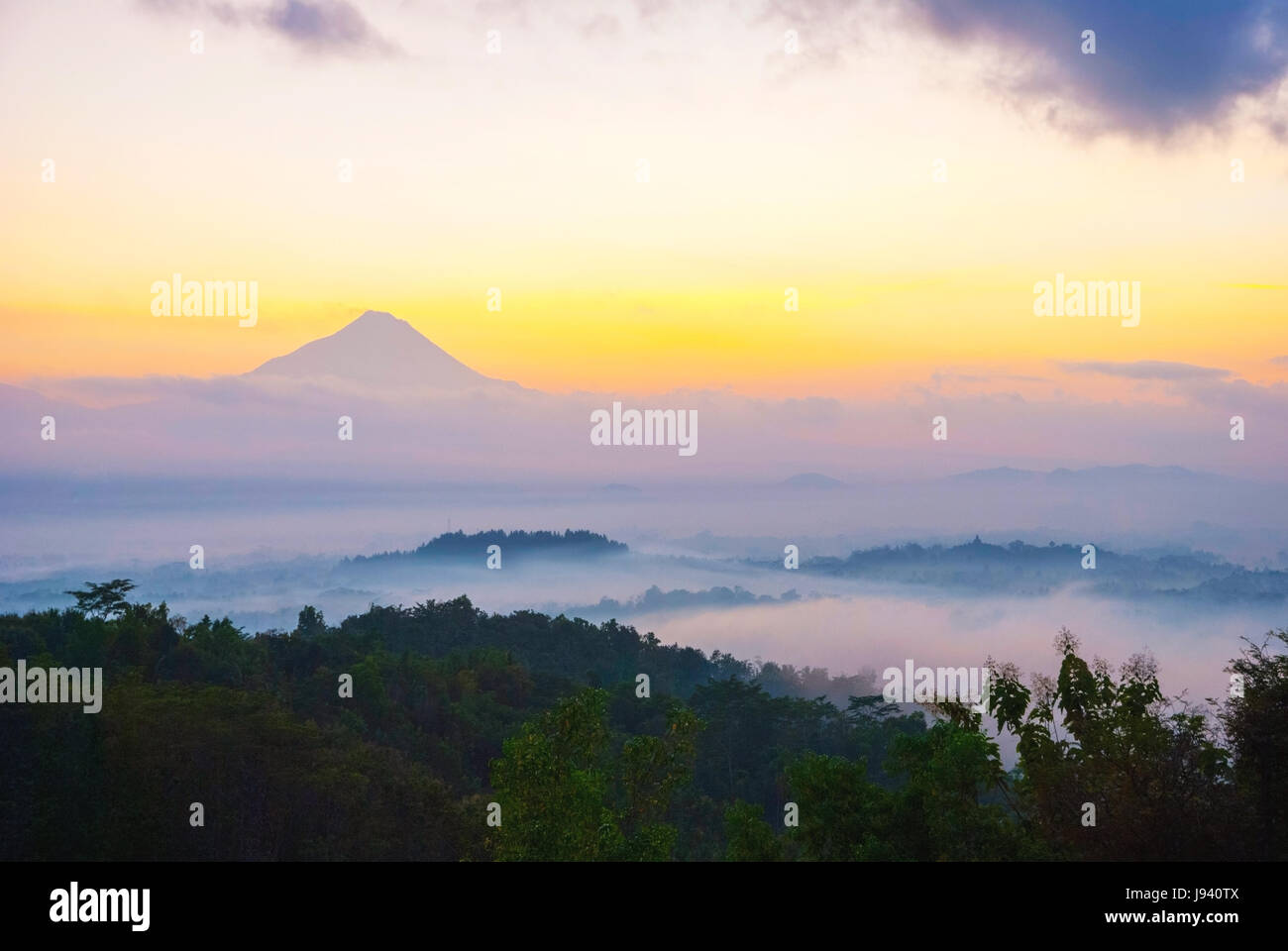Colorful sunrise over jungle with Merapi volcano behind and Borobudur ...