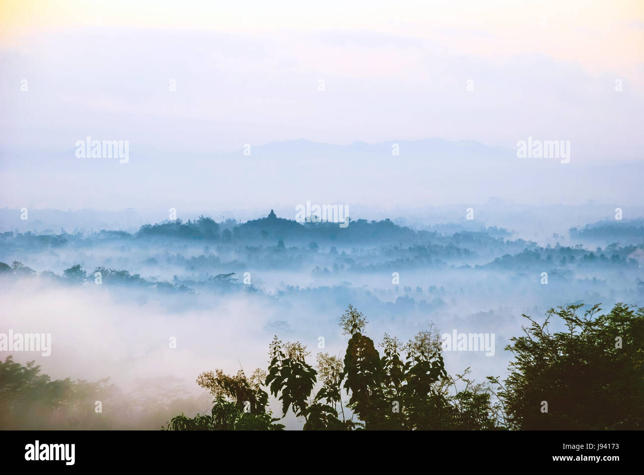 Colorful sunrise over jungle with Merapi volcano behind and Borobudur ...
