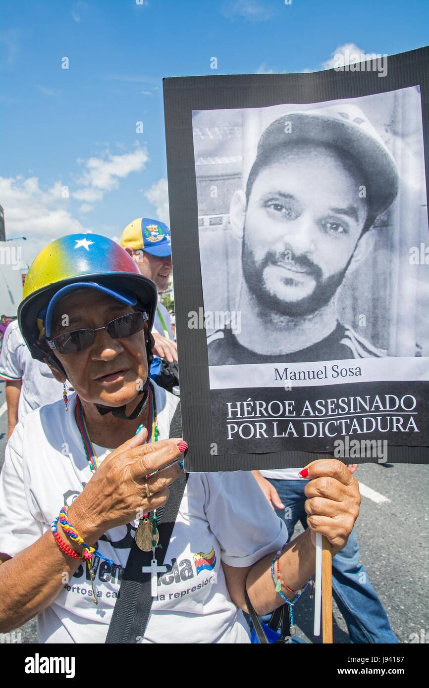 An elderly lady carries a sign that reminds Manuel Sosa, murdered by ...