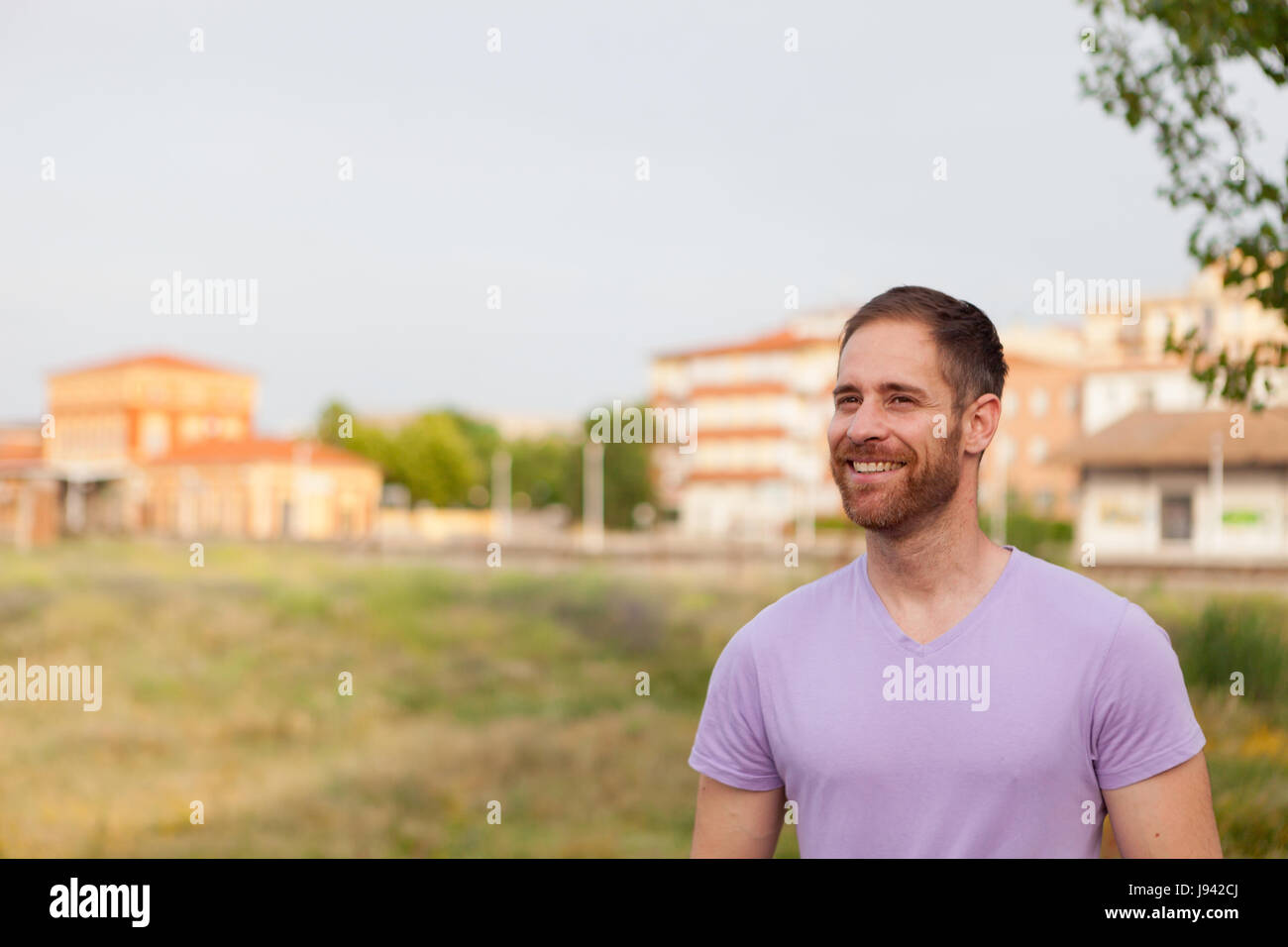 Attractive happy guy with a town of background Stock Photo - Alamy