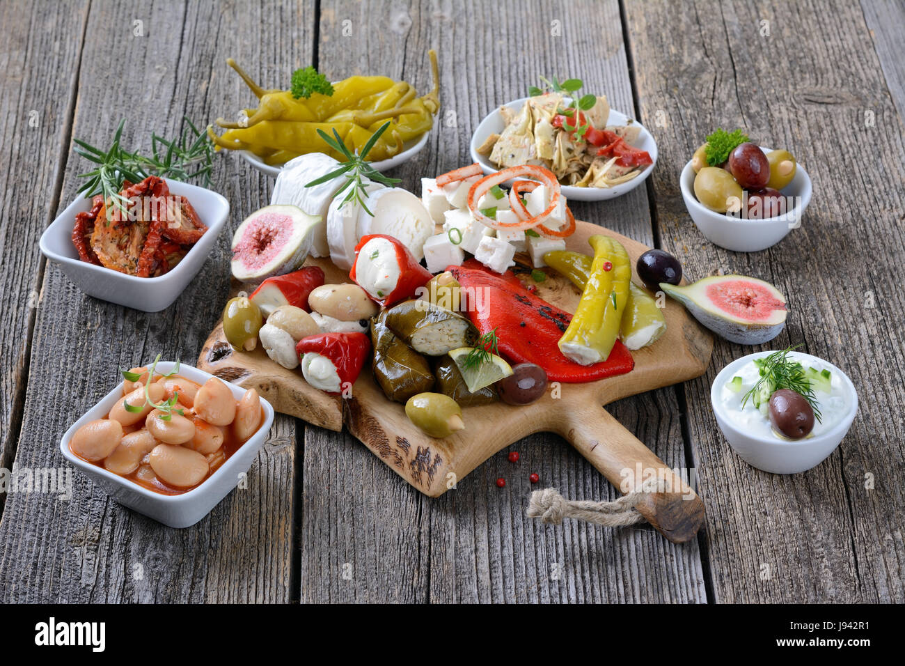 A selection of typical Greek mixed appetizers served on a wooden table ...