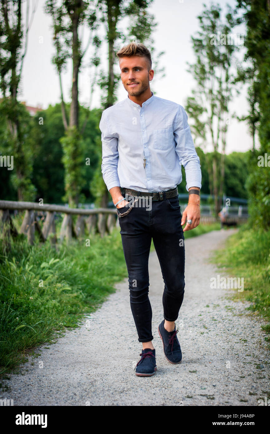 Handsome young man walking in city park Stock Photo - Alamy